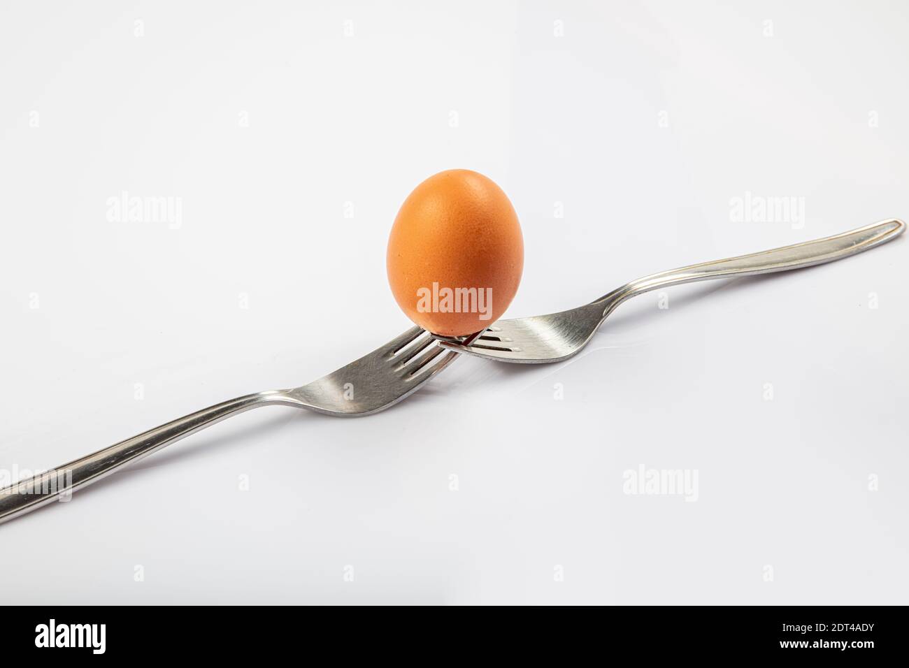 Still life photography. Two forks together create a case for a white ...