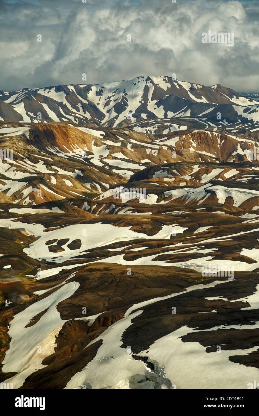 Aerial view of rhyolite mountains partially covered in snow ...