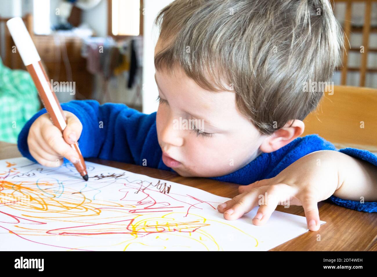 Close-up of boy painting on white paper with brown color pen Stock ...