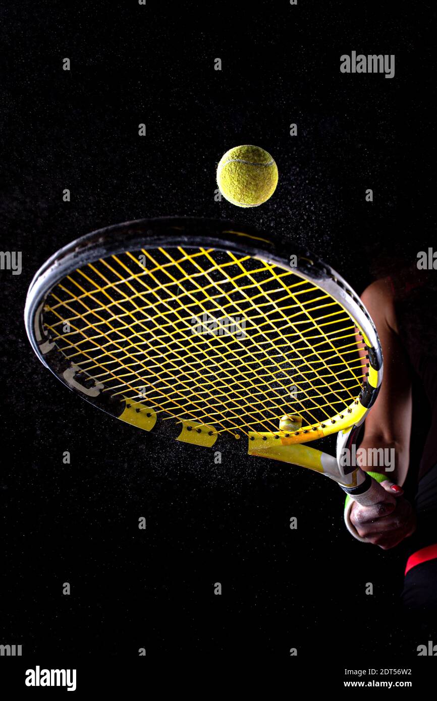Tennis ball bouncing on racket. Dirt or magnesium dust dots visible in ...