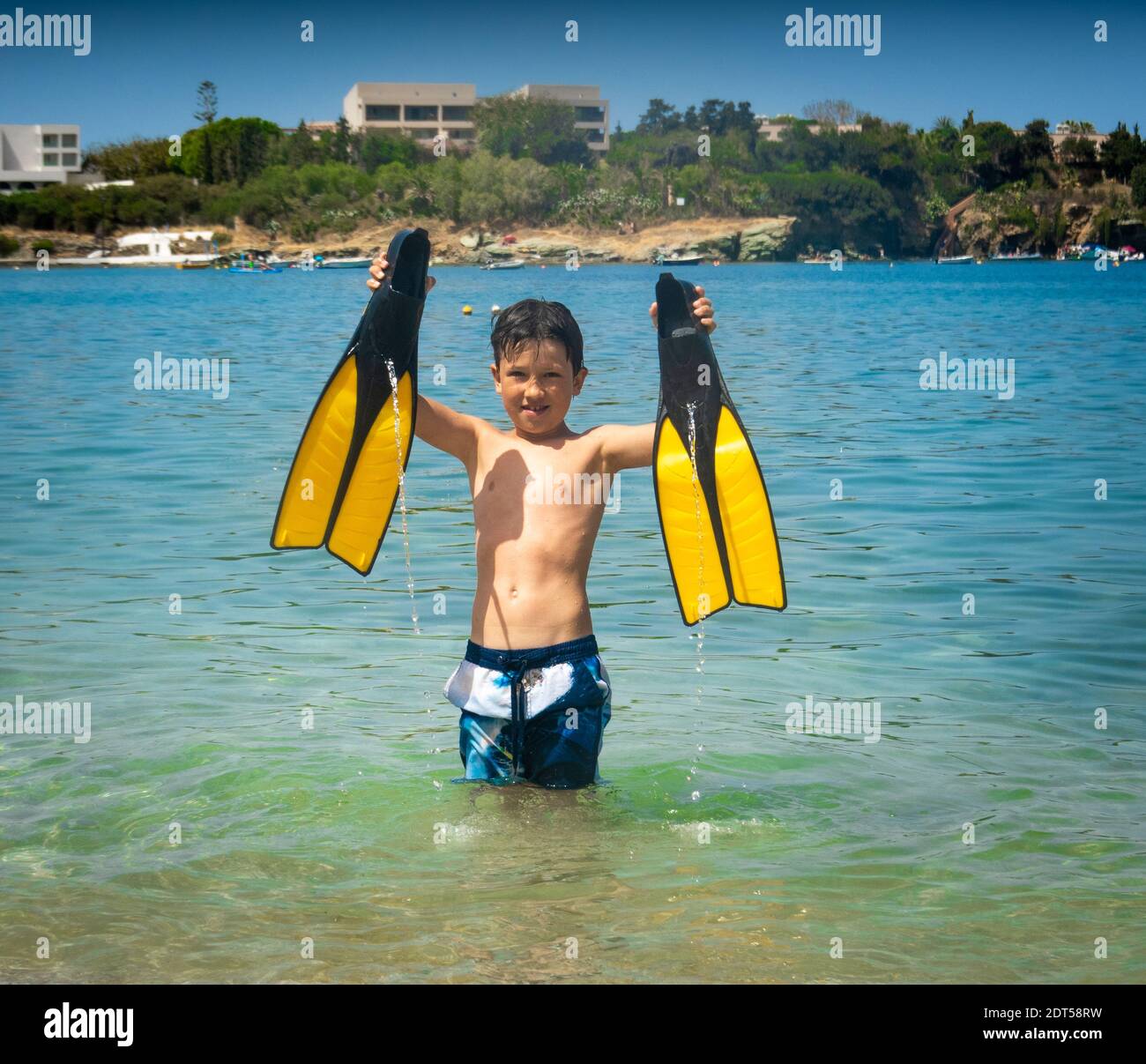 Portrait og boy showing diving flipper and standing in sea Stock Photo ...