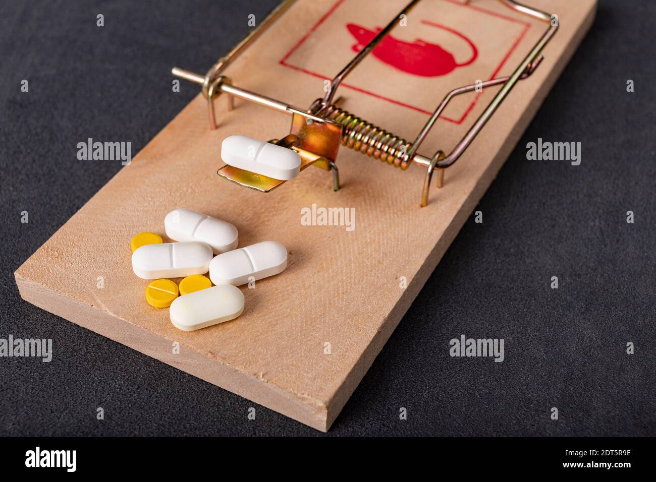 Medical tablets placed in a mousetrap. A trap for people in the form of ...