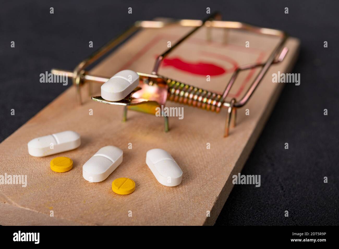 Medical tablets placed in a mousetrap. A trap for people in the form of ...
