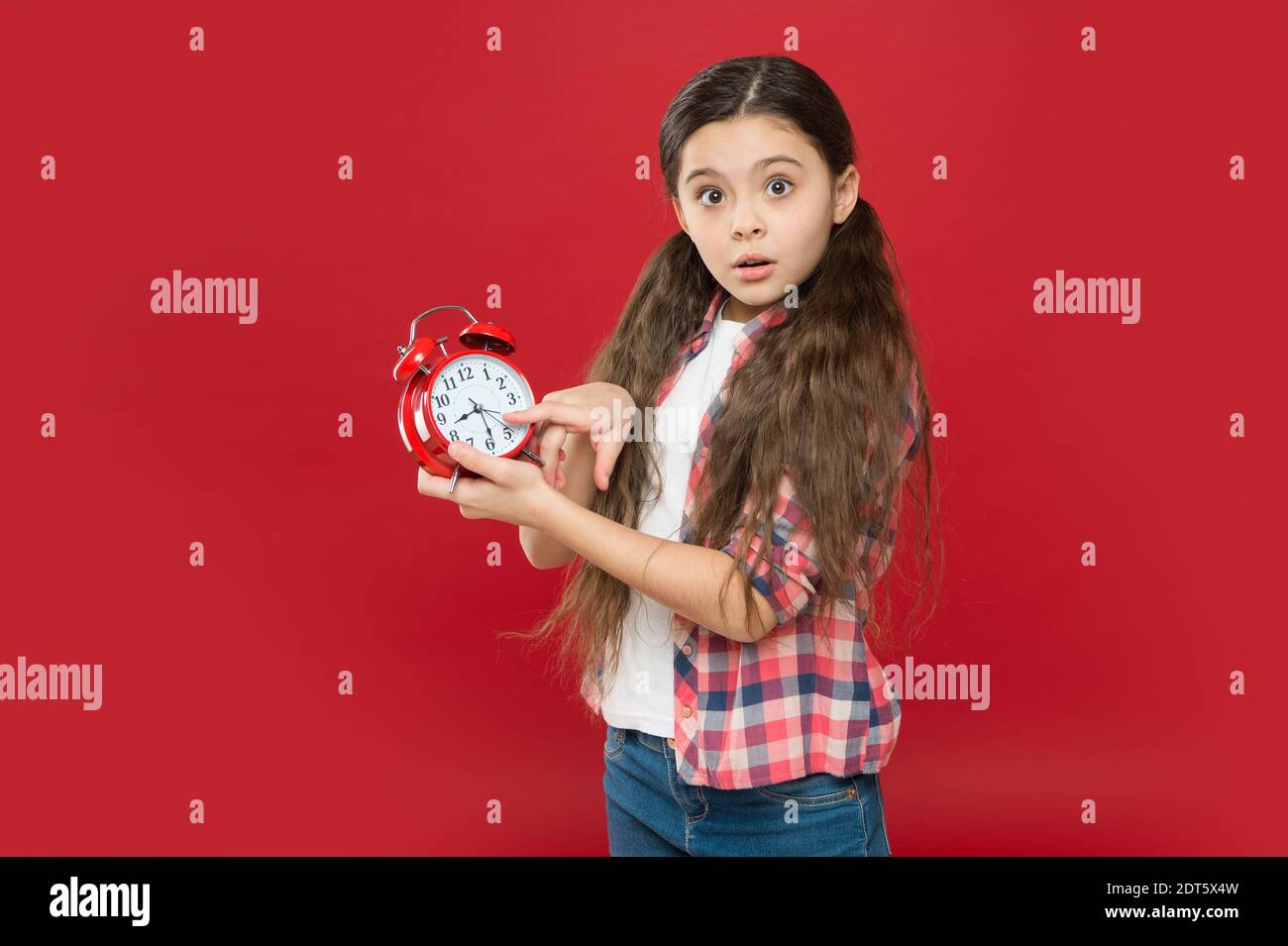 surprised kid girl showing time on vintage watch, alarm Stock Photo - Alamy