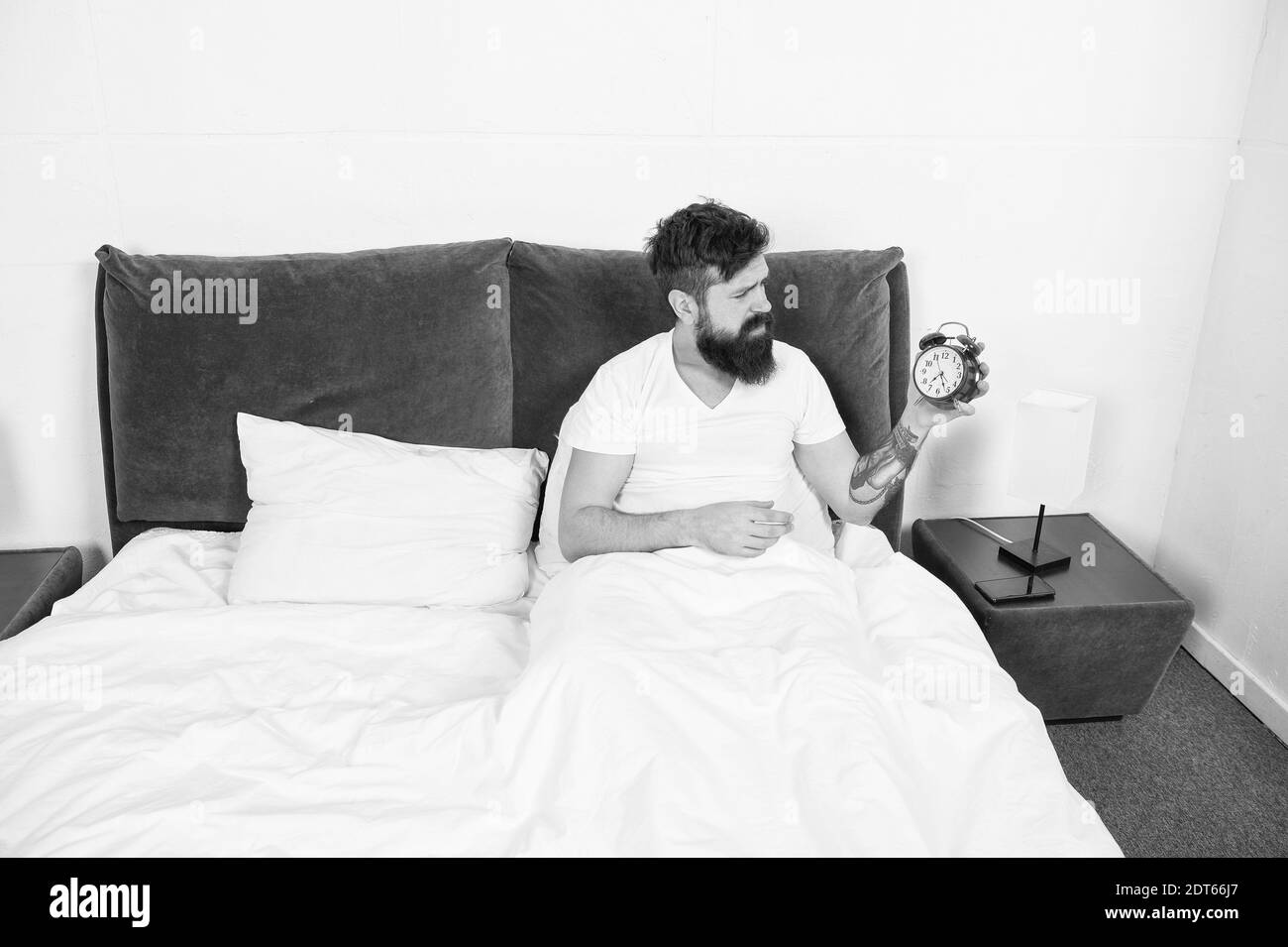 Morning again. Stressful man wake up turn off alarm clock. Time to ...