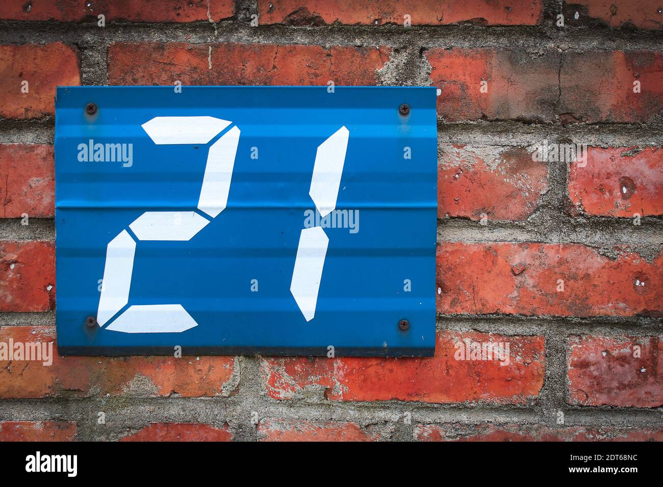 Blue metallic sign on red brick wall with digit 21, Poland Stock Photo ...