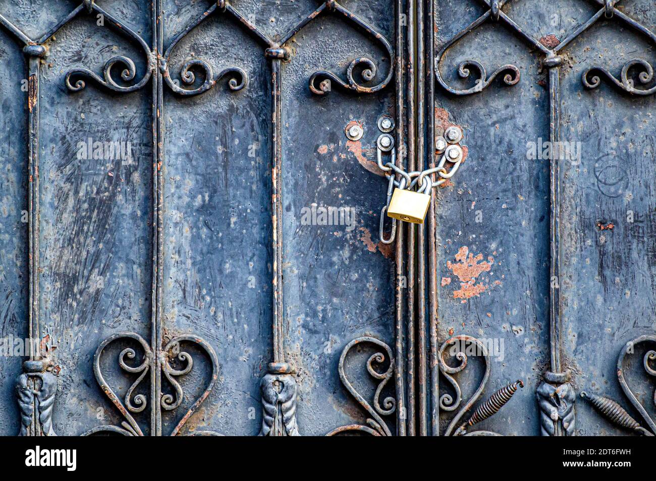 The old iron gates are closed with a padlock. The passage is blocked ...