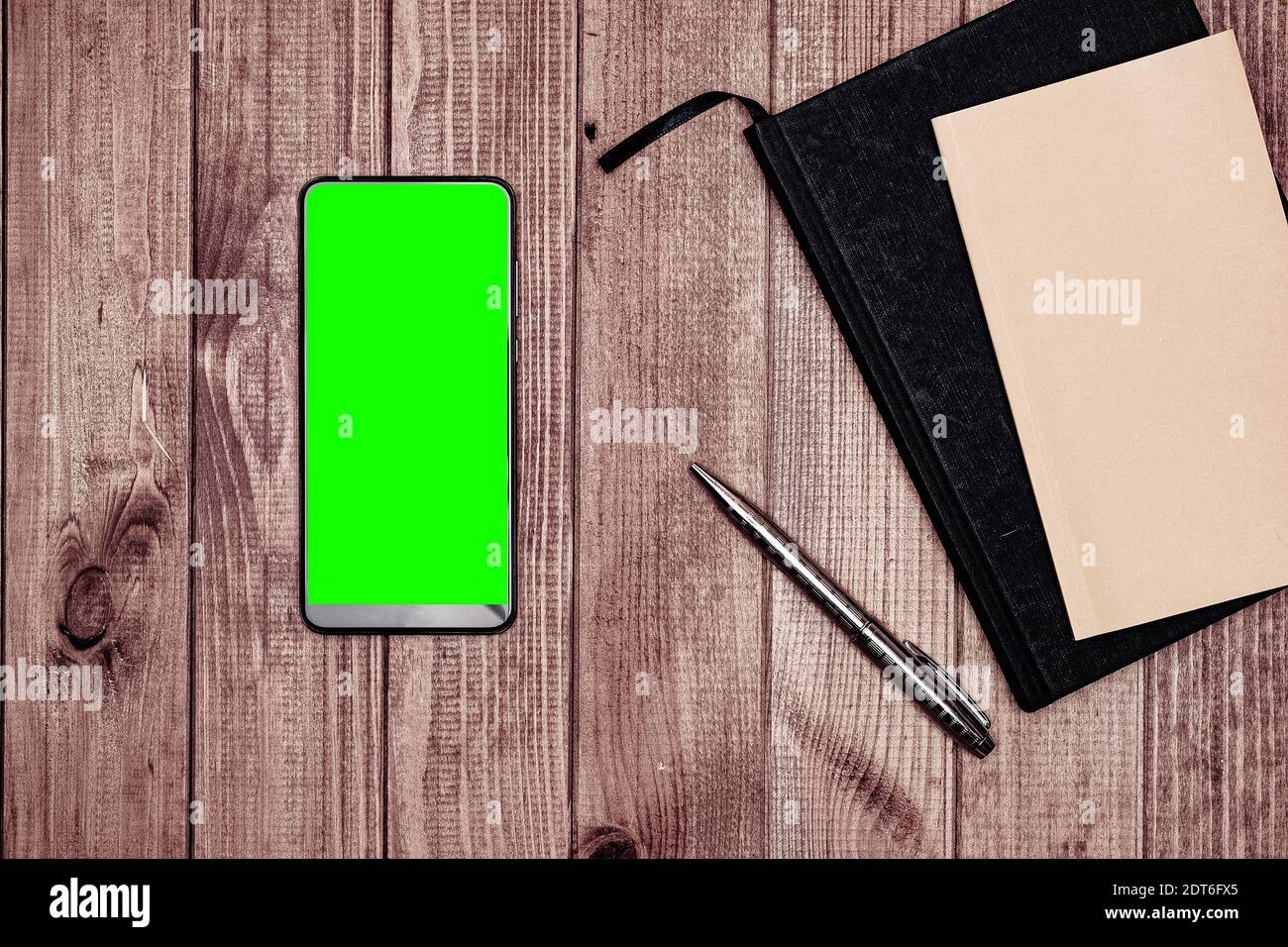 smartphone with green screen, notepad and pen on wood background Stock ...