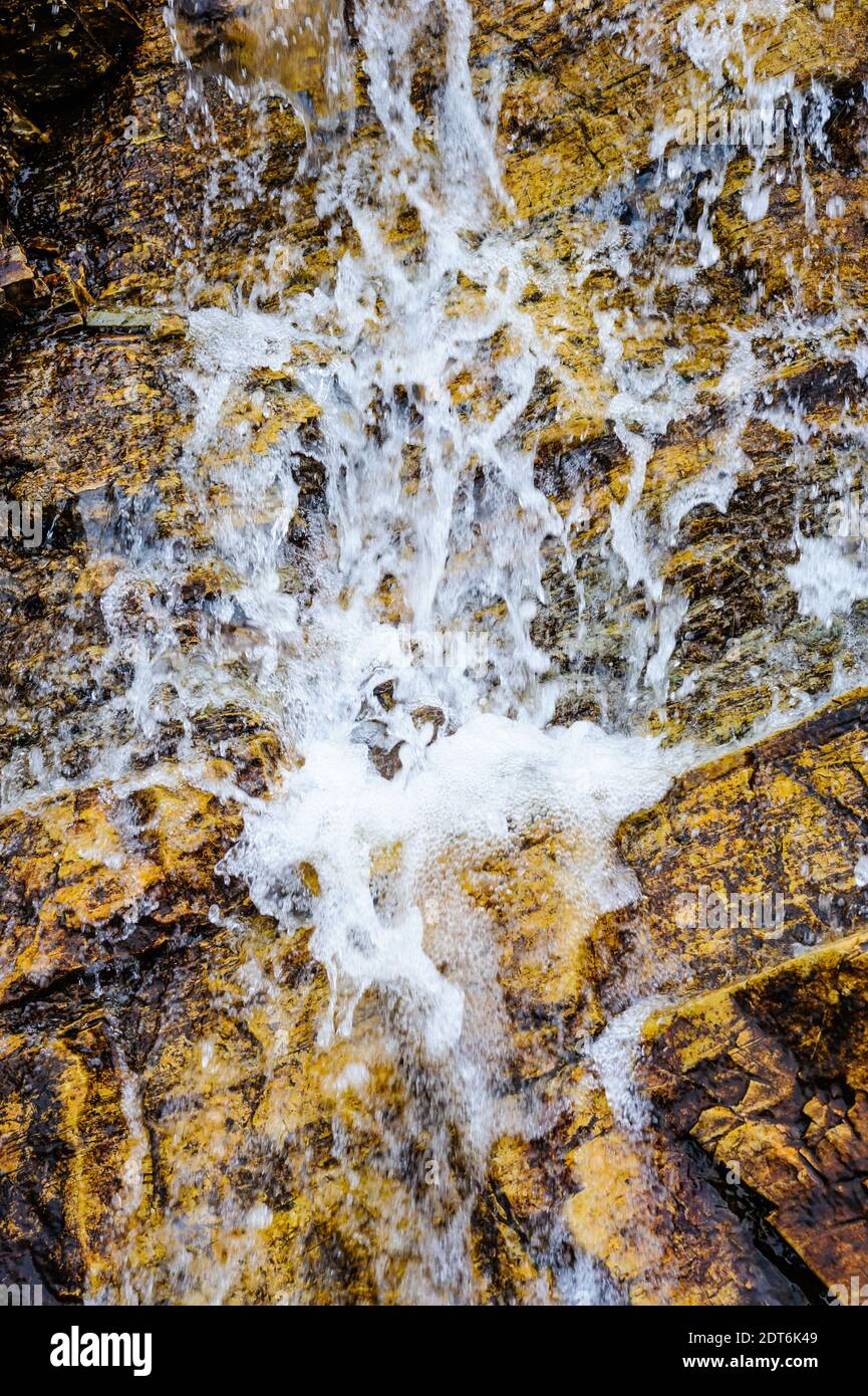 Water splashing over uneven rock surface Stock Photo - Alamy