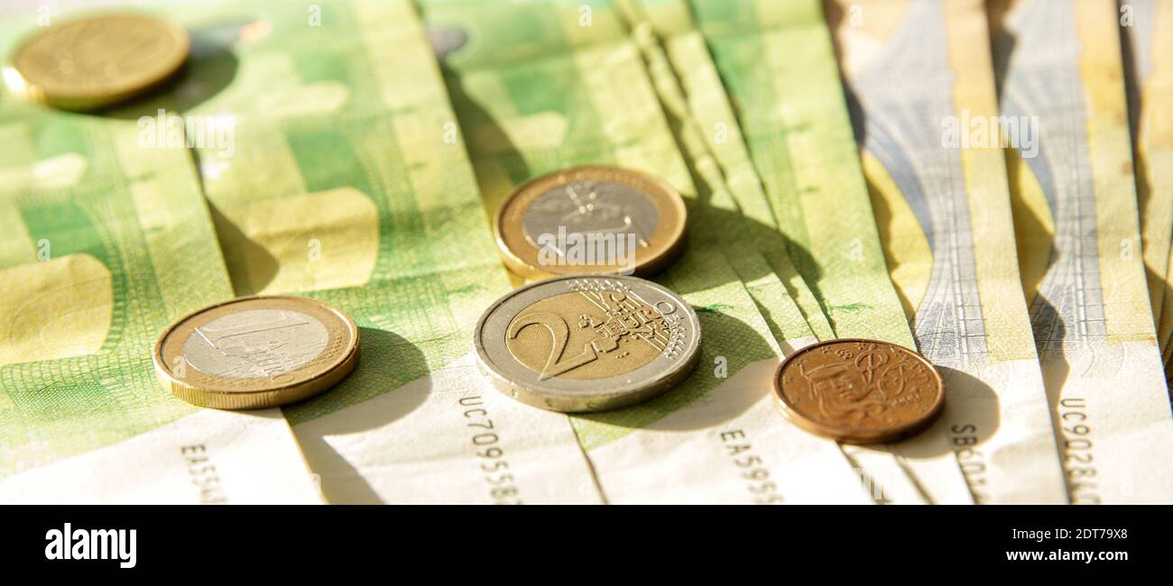 paper banknotes and coins of European currency in sunlight. banner ...