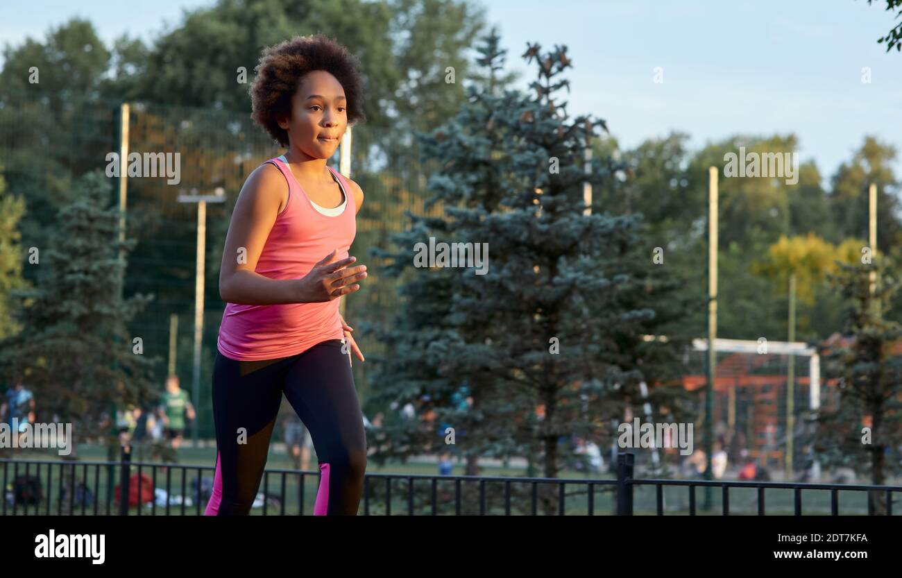 Sporty Afro American girl running on the street Stock Photo - Alamy