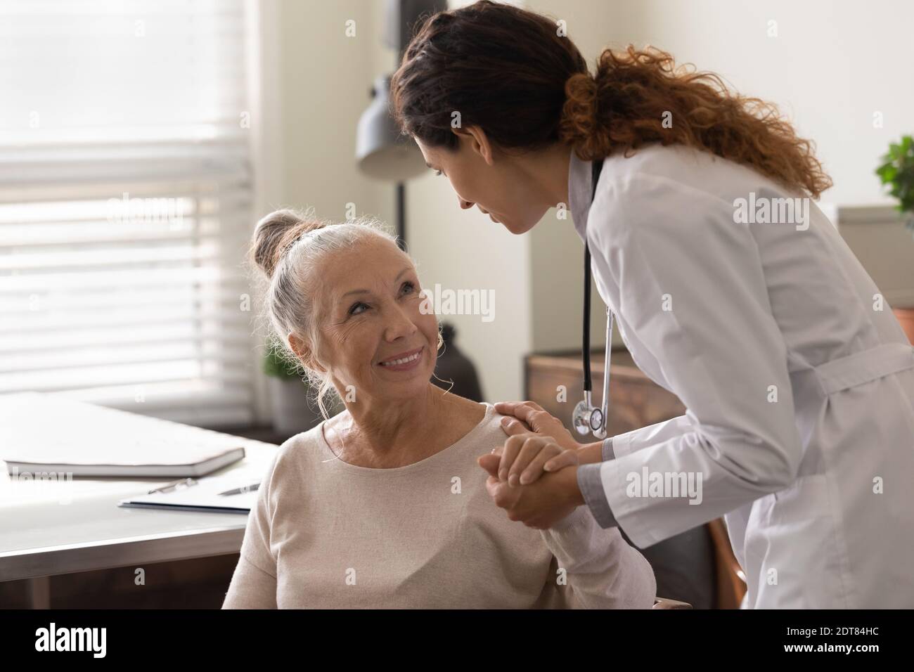 Caring female doctor comfort senior patient in hospital Stock Photo - Alamy