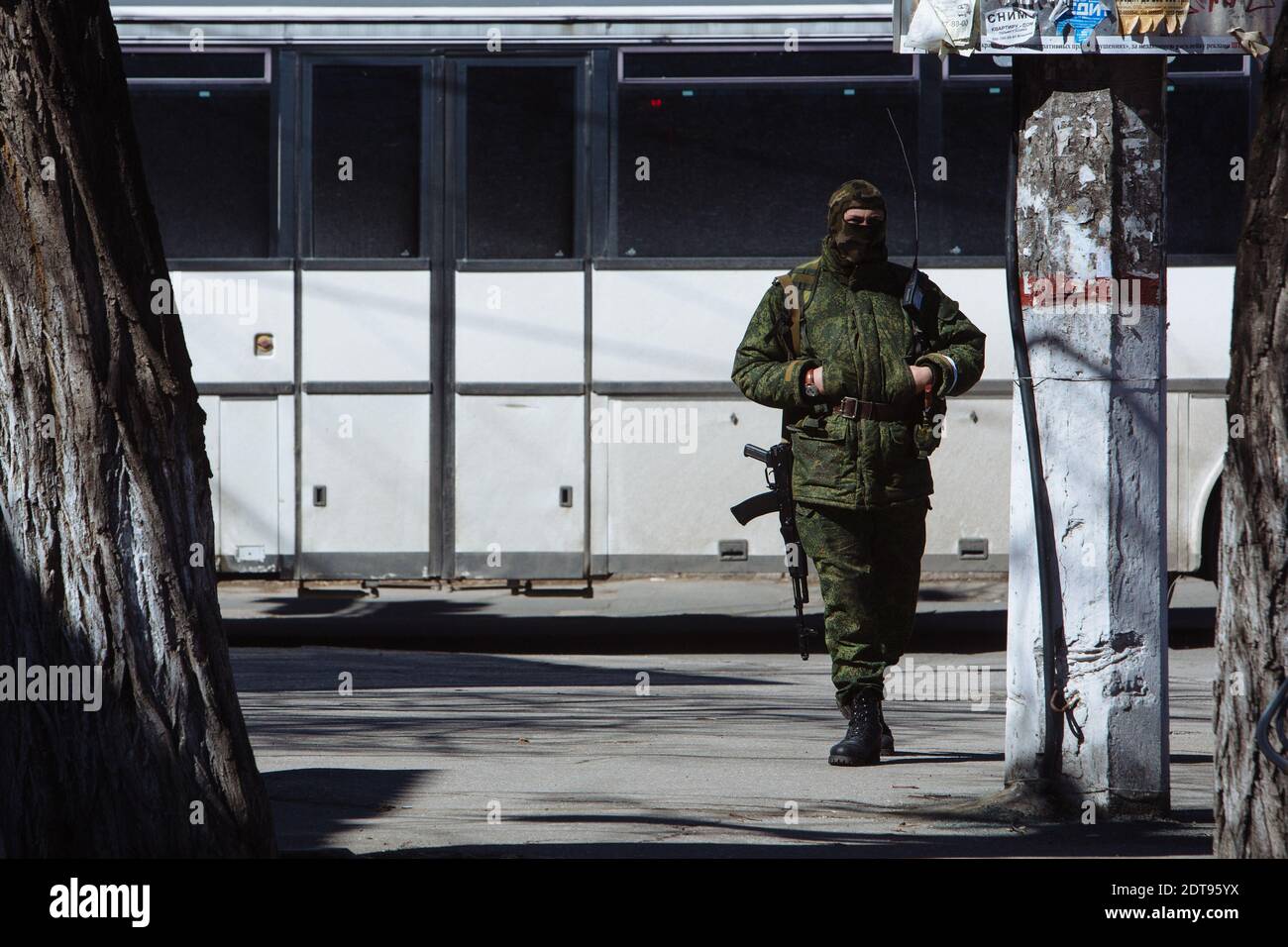 Armed men, believed to be Russian servicemen, stand guard outside a ...