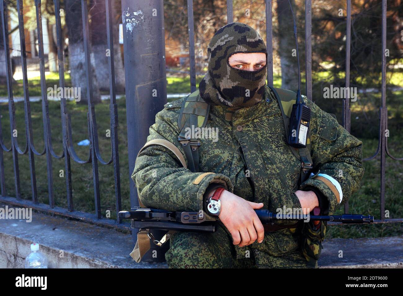 Armed men, believed to be Russian servicemen, stand guard outside a ...