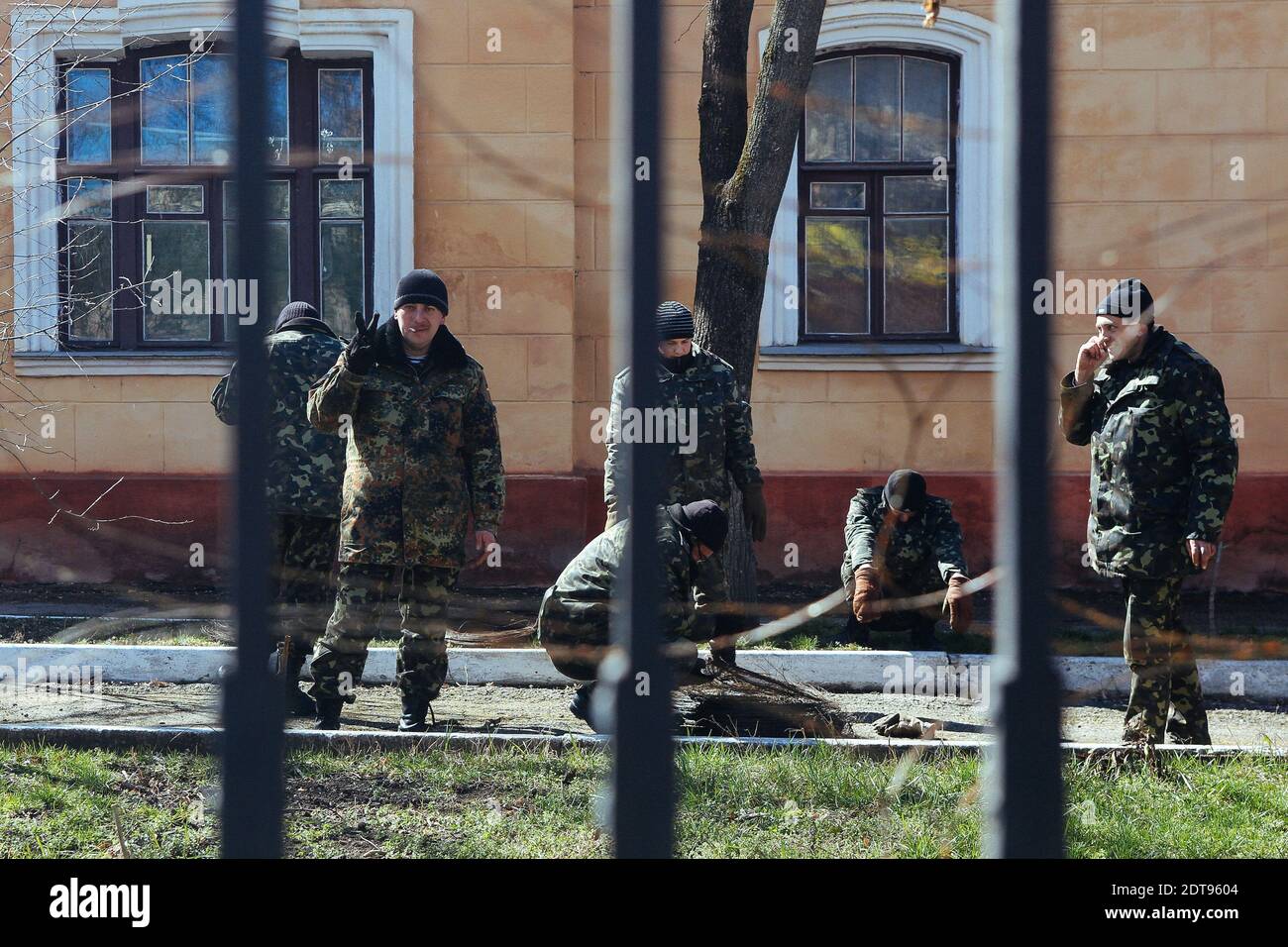 Armed men, believed to be Russian servicemen, stand guard outside a ...