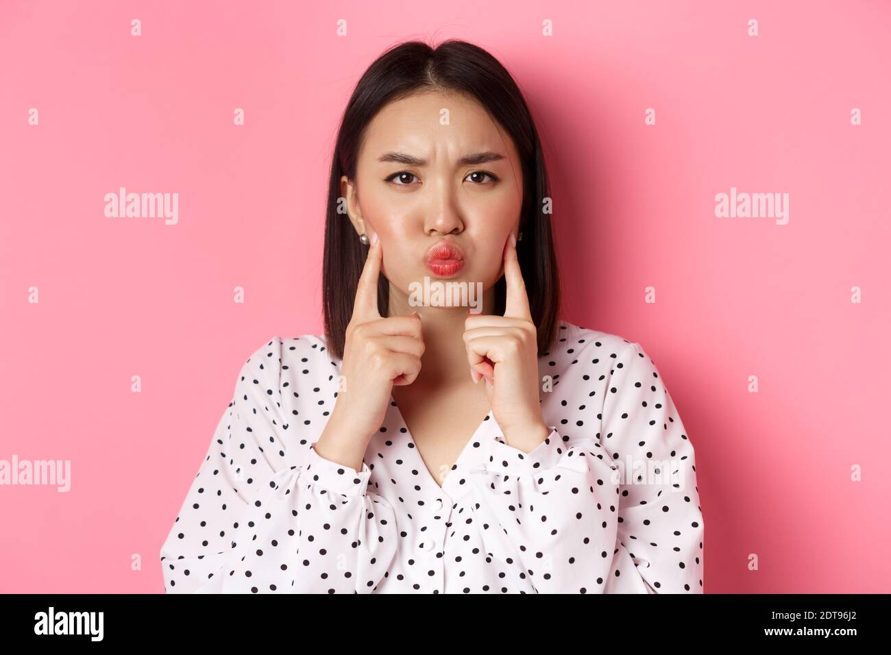 Beauty and lifestyle concept. Cute asian woman making grumpy face ...