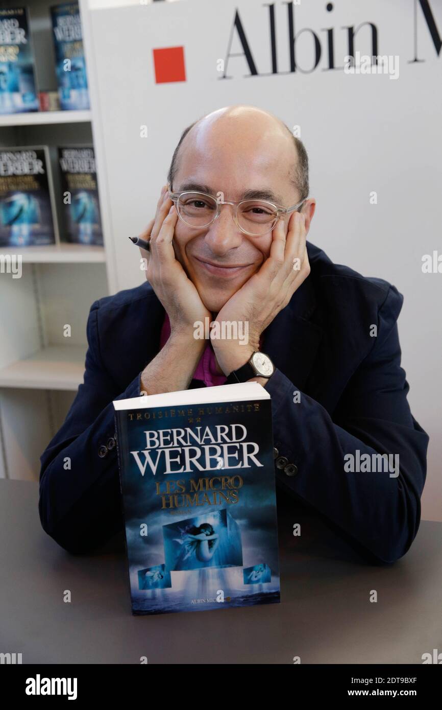 Bernard Werber signs copies of his book during the 34th Salon du Livre ...