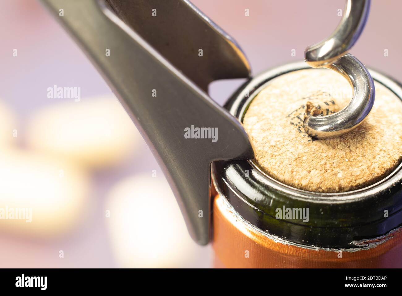 corkscrew pulling a cork out of its green glass bottle and copper ...
