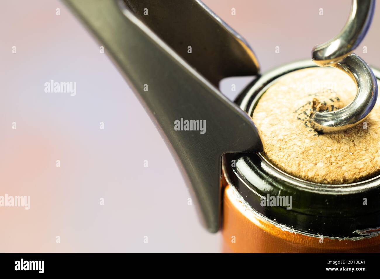 corkscrew pulling a cork out of its green bottle and copper colored ...