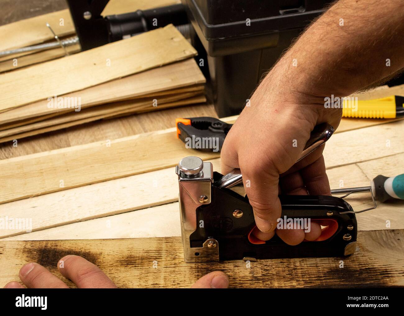 Man fastens boards with a stapler Stock Photo - Alamy