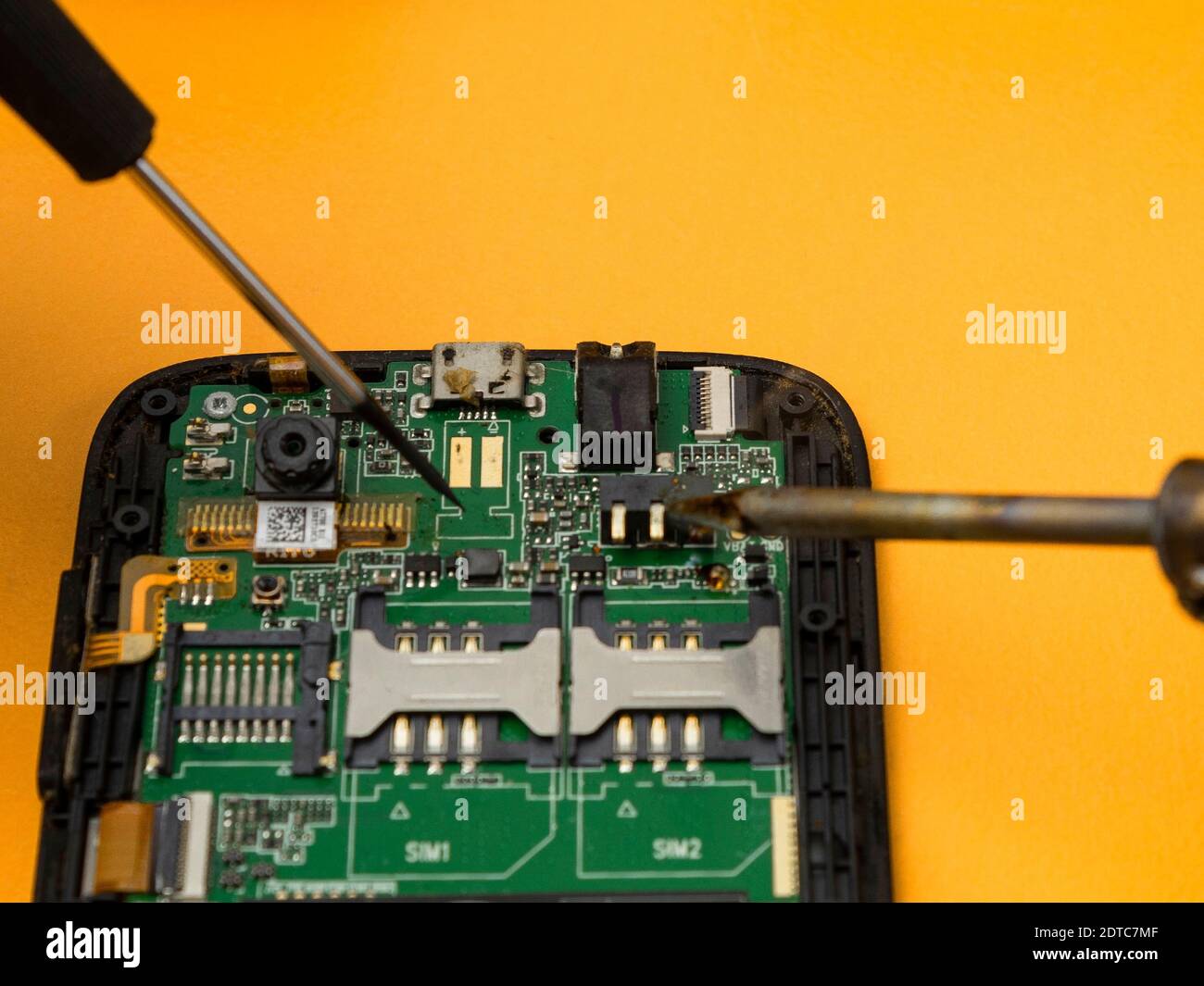 Repairing a mobile phone with a soldering iron and screwdriver Stock ...