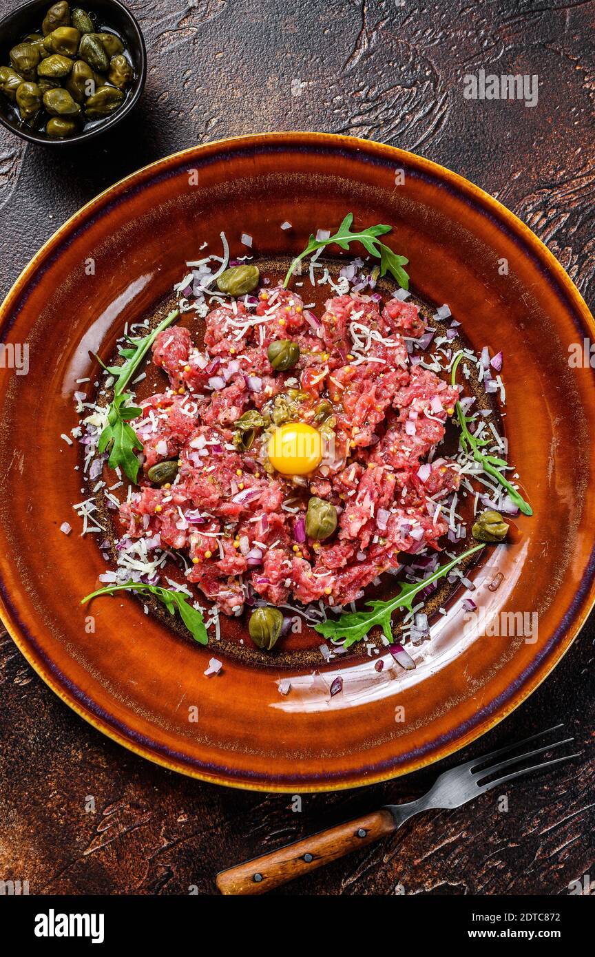 French cuisine Beef tartare with raw egg yolk. Dark background. Top ...
