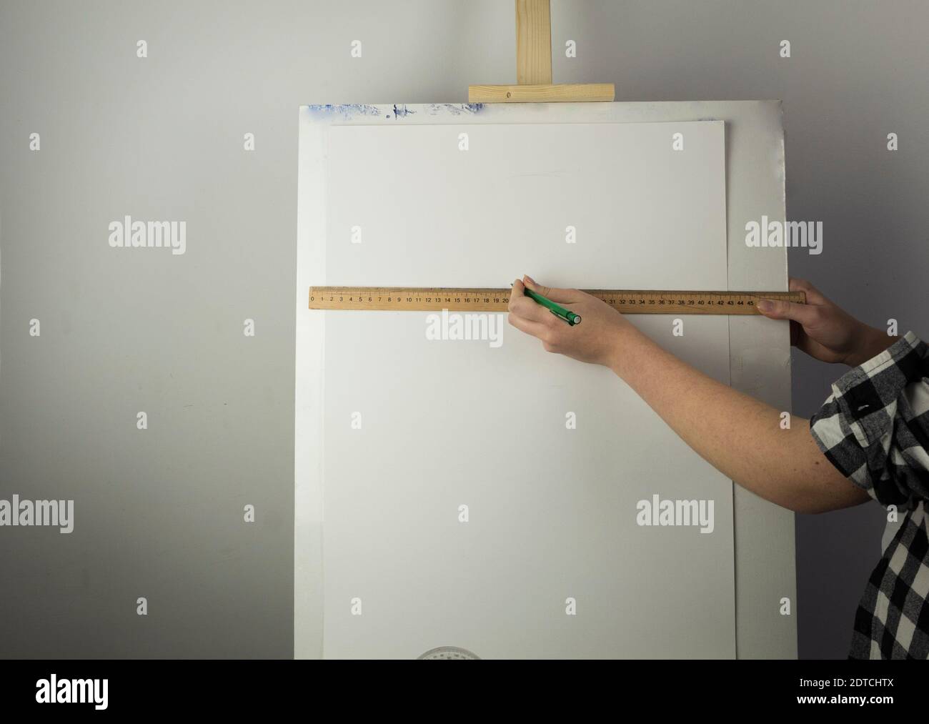 Girl-artist draws on a Whatman paper with a ruler and a pencil. Sketch ...