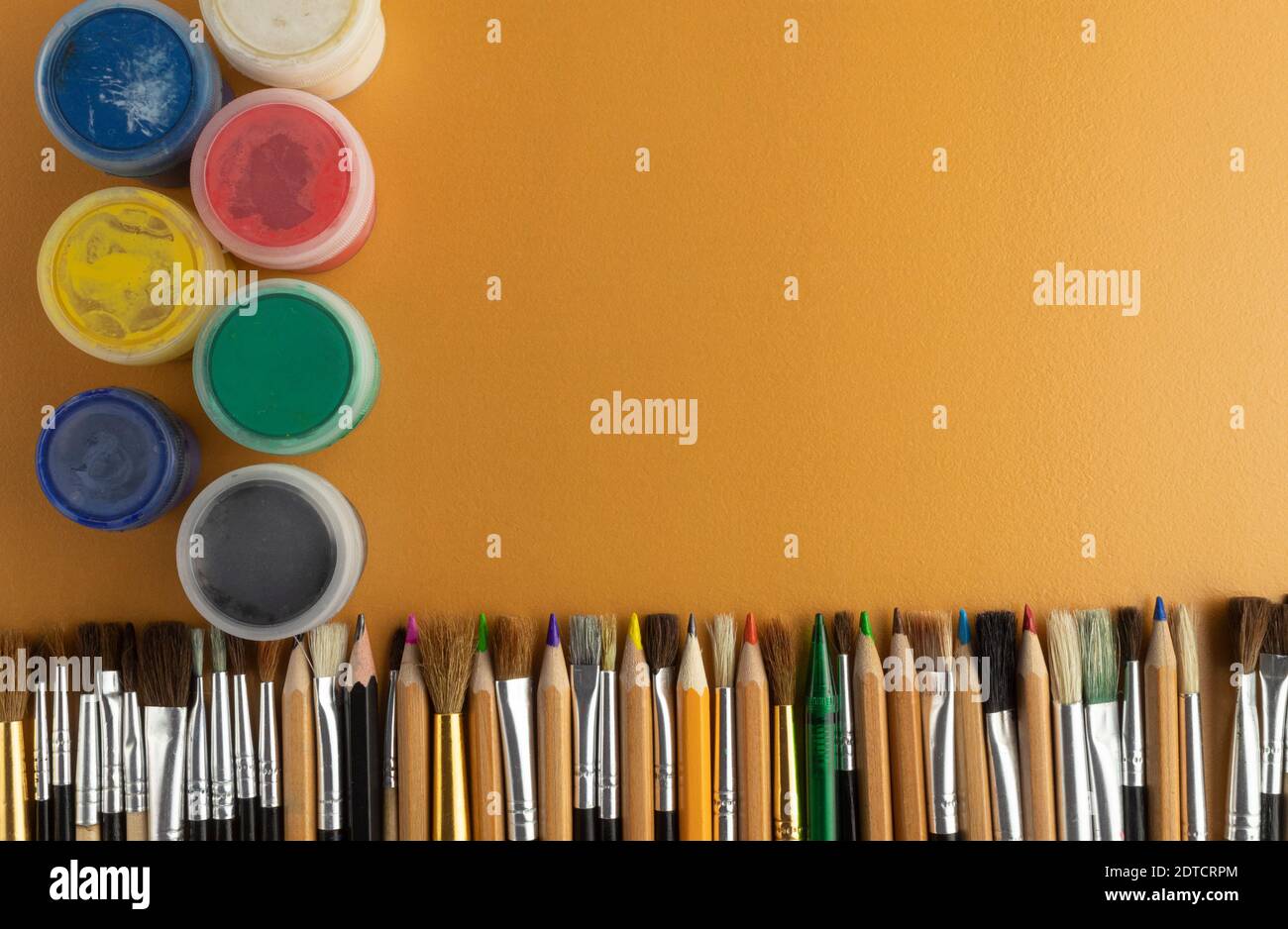 Pencils and brushes for drawing are laid out on a table. Working ...