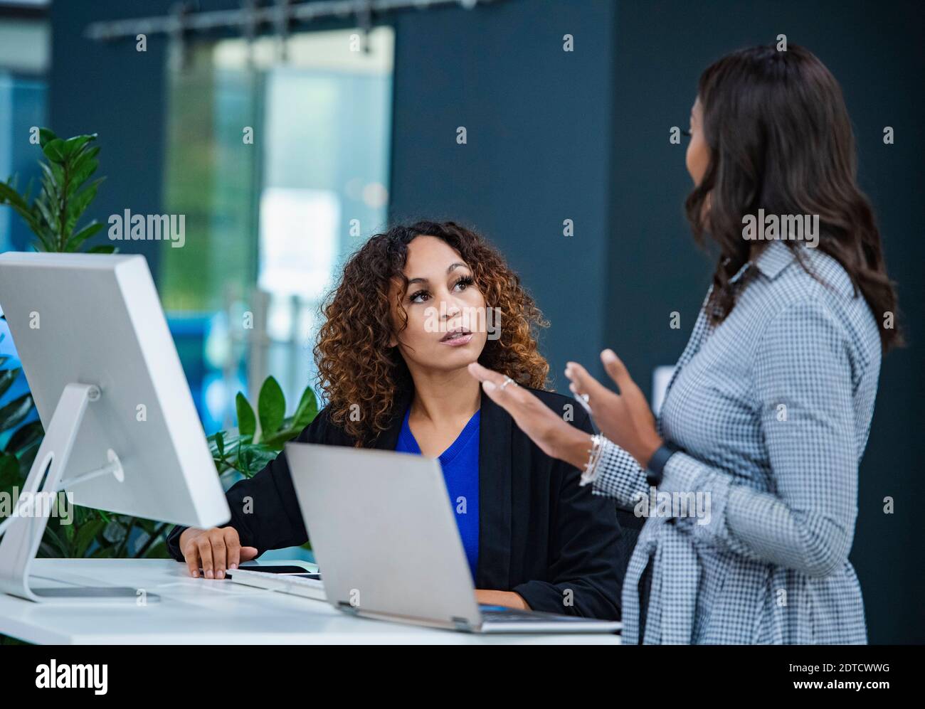 Two women talking in office Stock Photo - Alamy