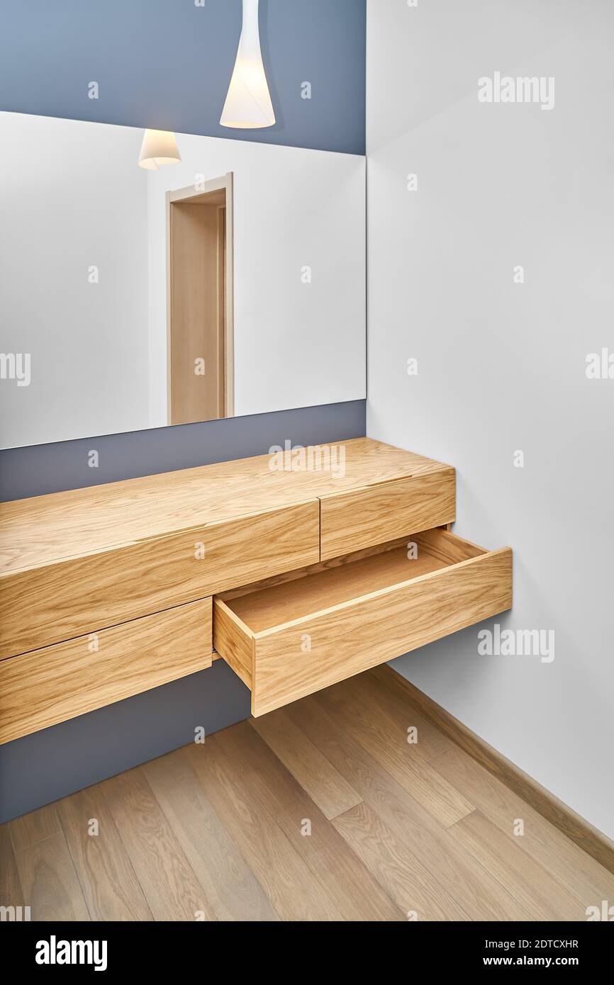 Stylish floating cabinet of natural wood with opened empty drawer under ...