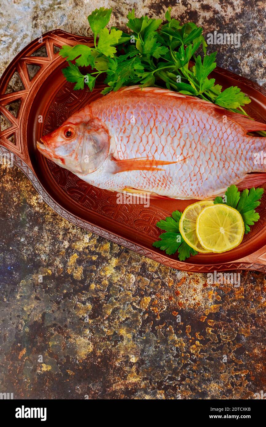 Fresh fish with herbs and lemon on tray. Top view Stock Photo - Alamy