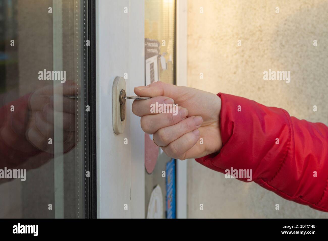Woman closes the door lock. The key in the lock of the old door Stock ...