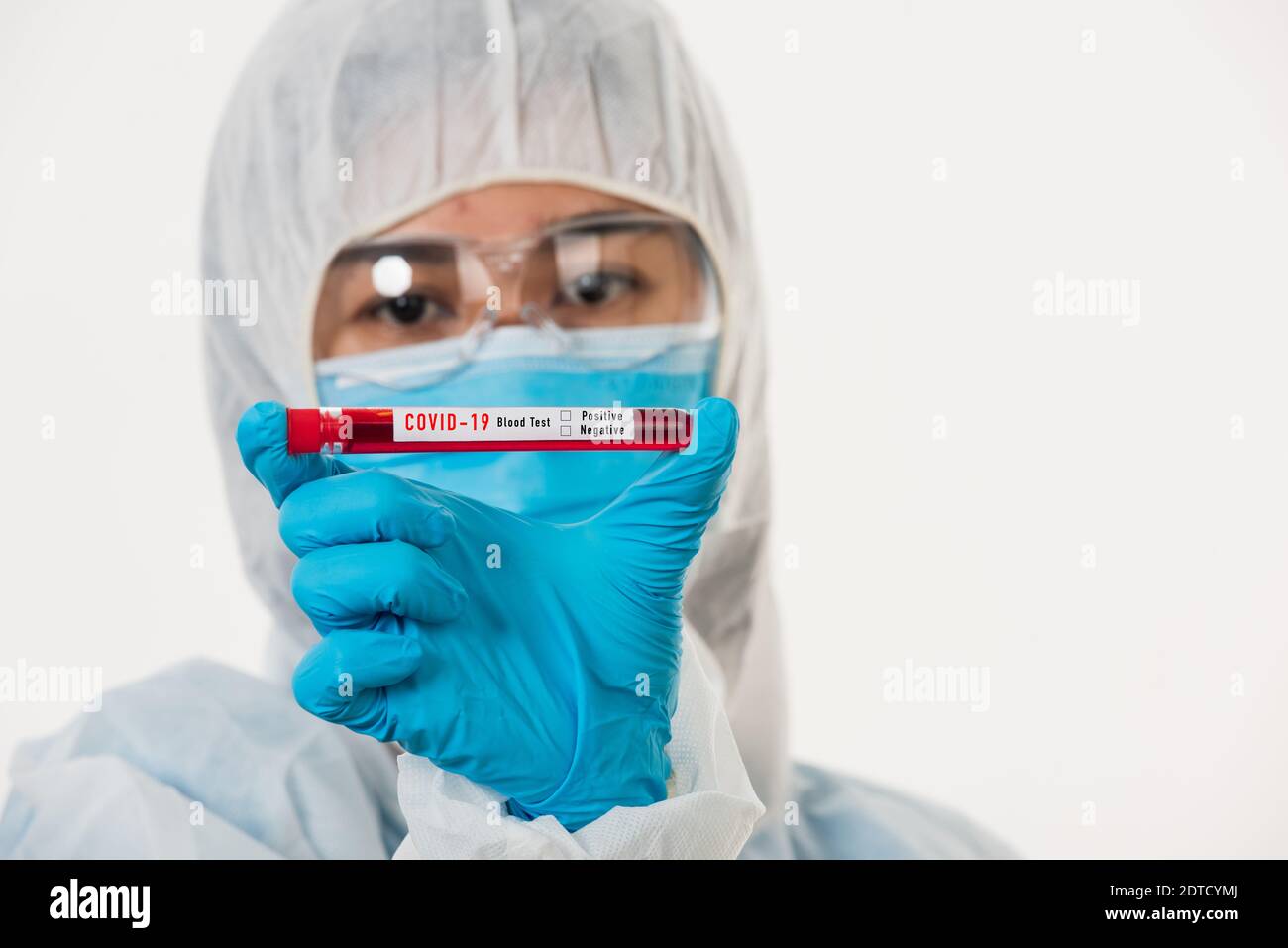 Medical scientist in PPE uniform wear a mask holding test tube ...