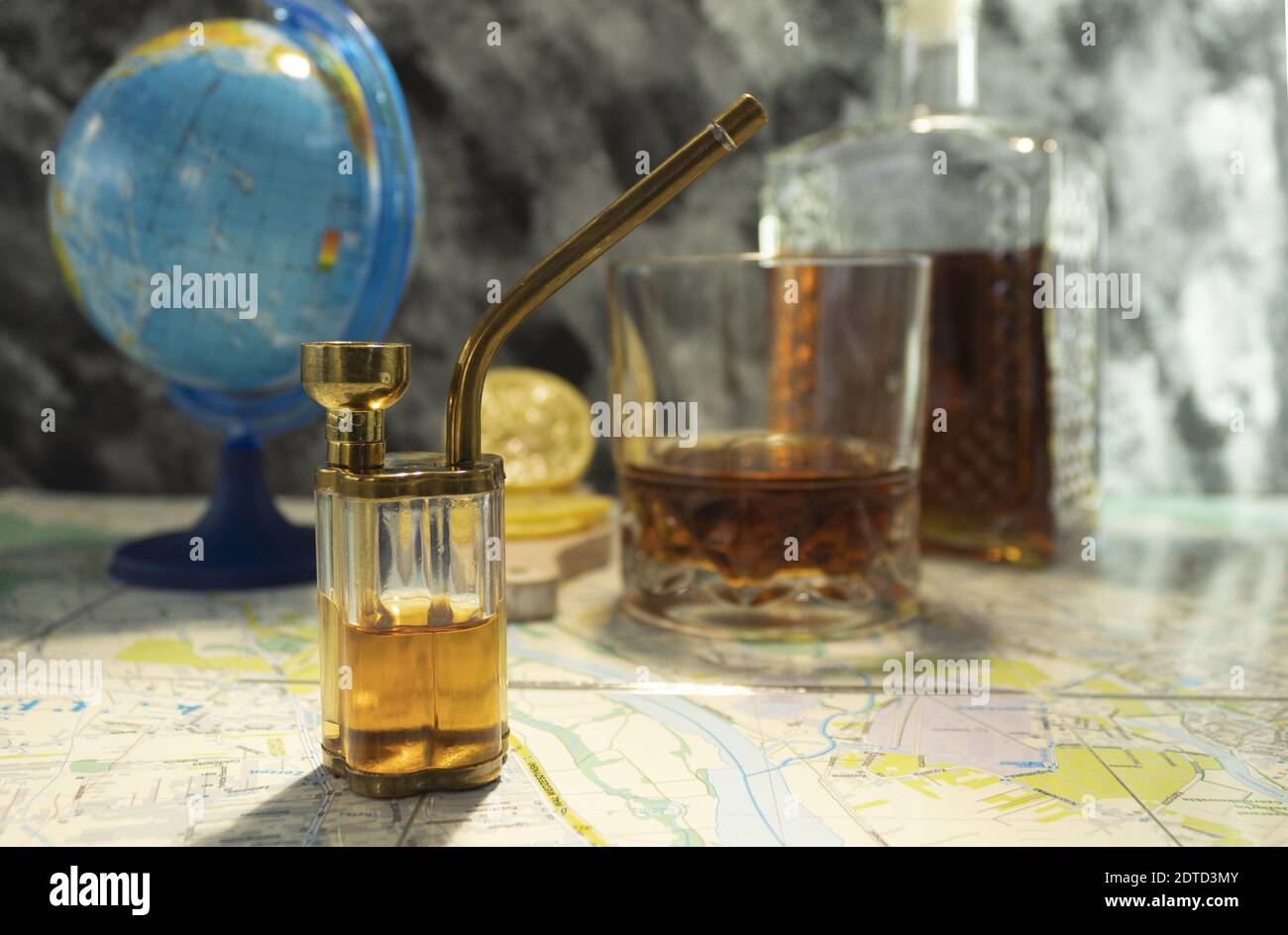 Close-up of bong with marijuana and a bottle of whiskey on a table with ...