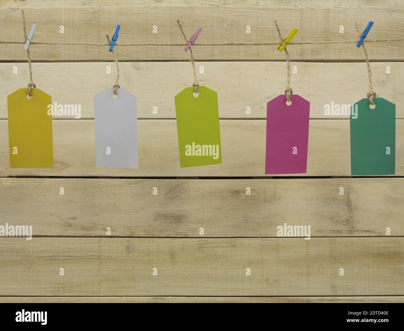 Colored tags are hung on a rope. Labels hanging on a rope with colored ...