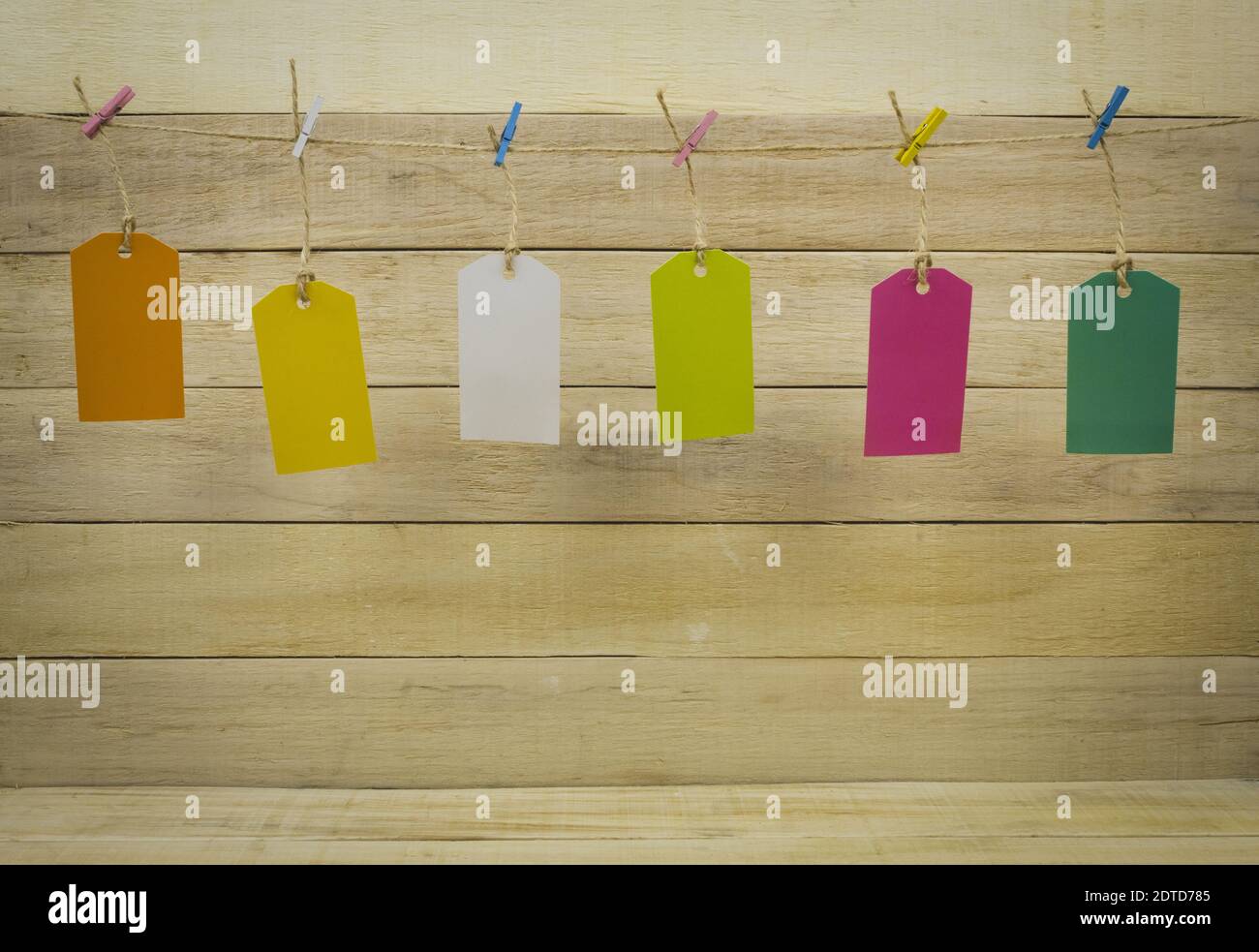 Labels hang on a rope with colored clothespins. Colored tags are hung ...