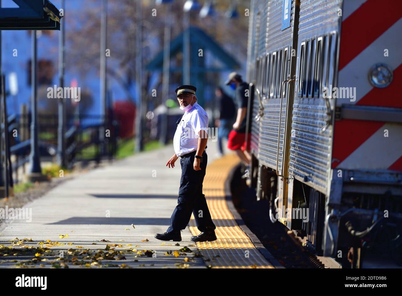 Winfield, Illinois, USA. A conductor sporting a face mask gets off his ...