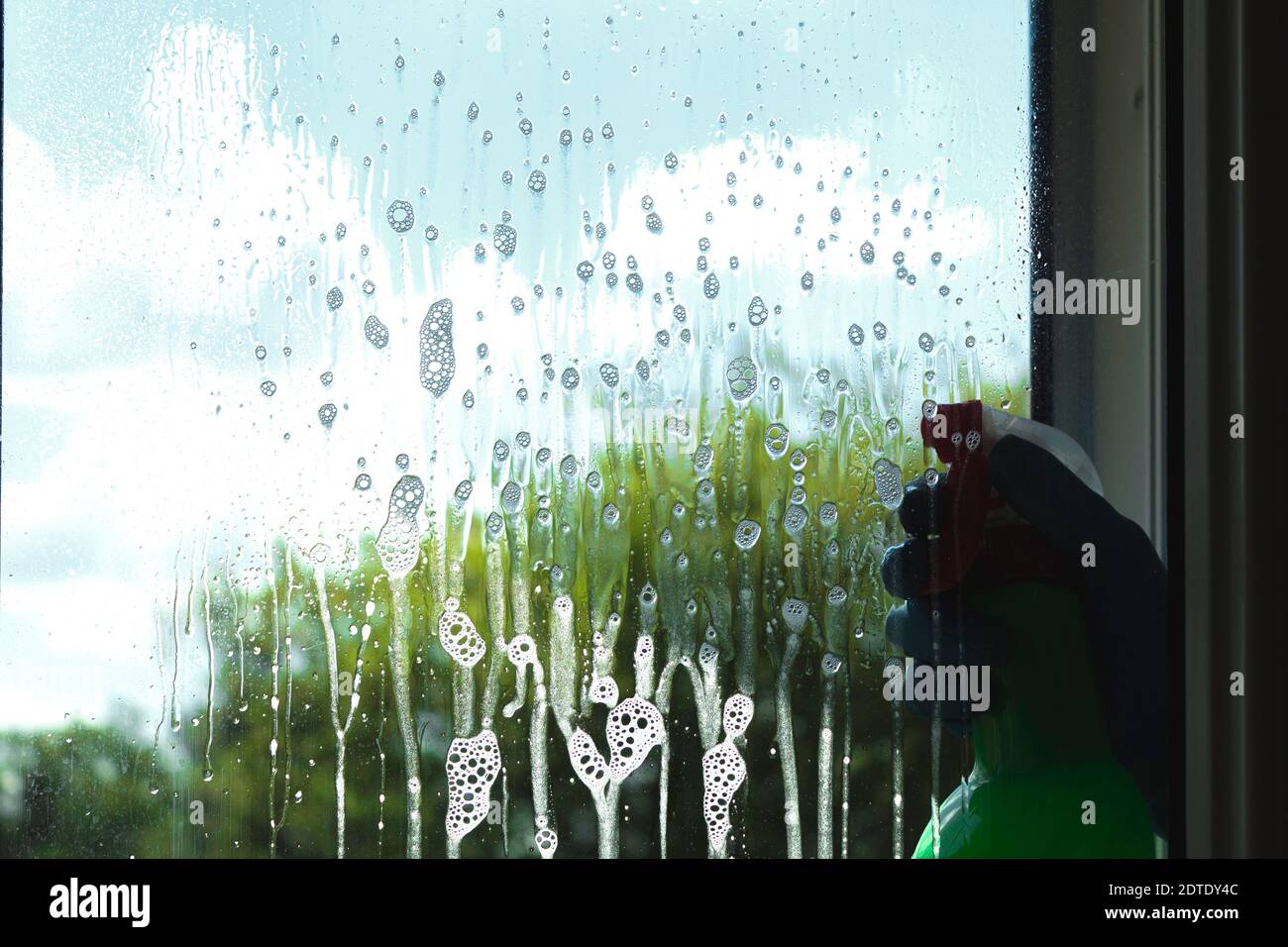 Detergent flows down the glass. Window washing and spraying window ...