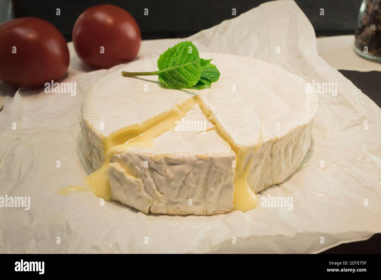 Sliced slice of Camembert cheese. Round cheese and fresh mint leaves ...
