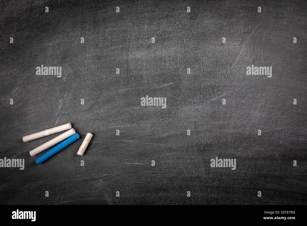 Black chalk board with chalk pieces. Scratches and white lines. Space ...