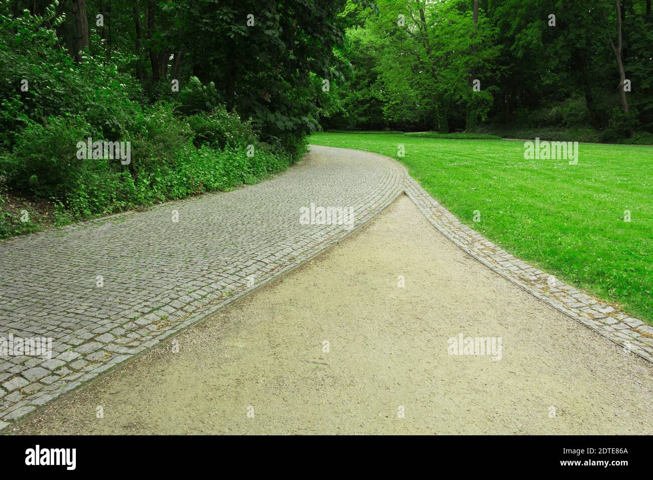 The path in the park is made of stone. Paving stones in a city park ...