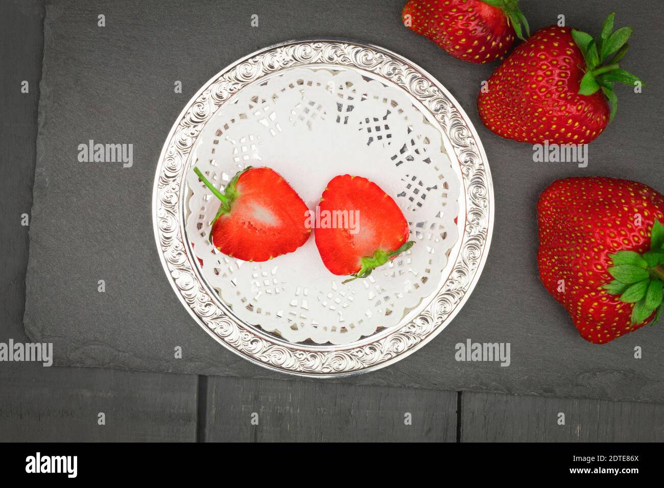 Strawberry is cut into two halves. Sugar and juicy strawberries are cut ...