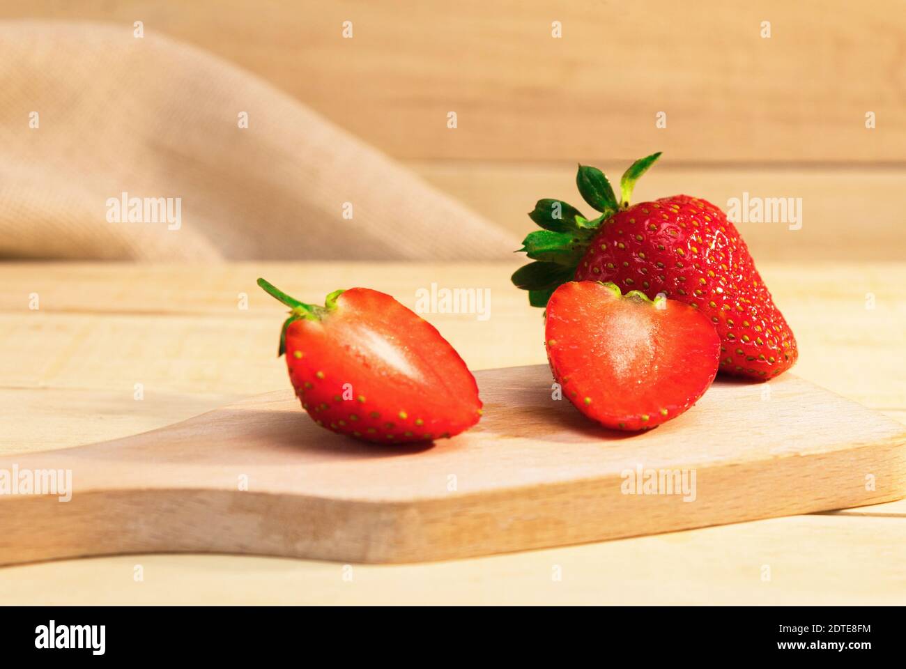 Strawberry is cut into two halves. Sugar and juicy strawberries are cut ...