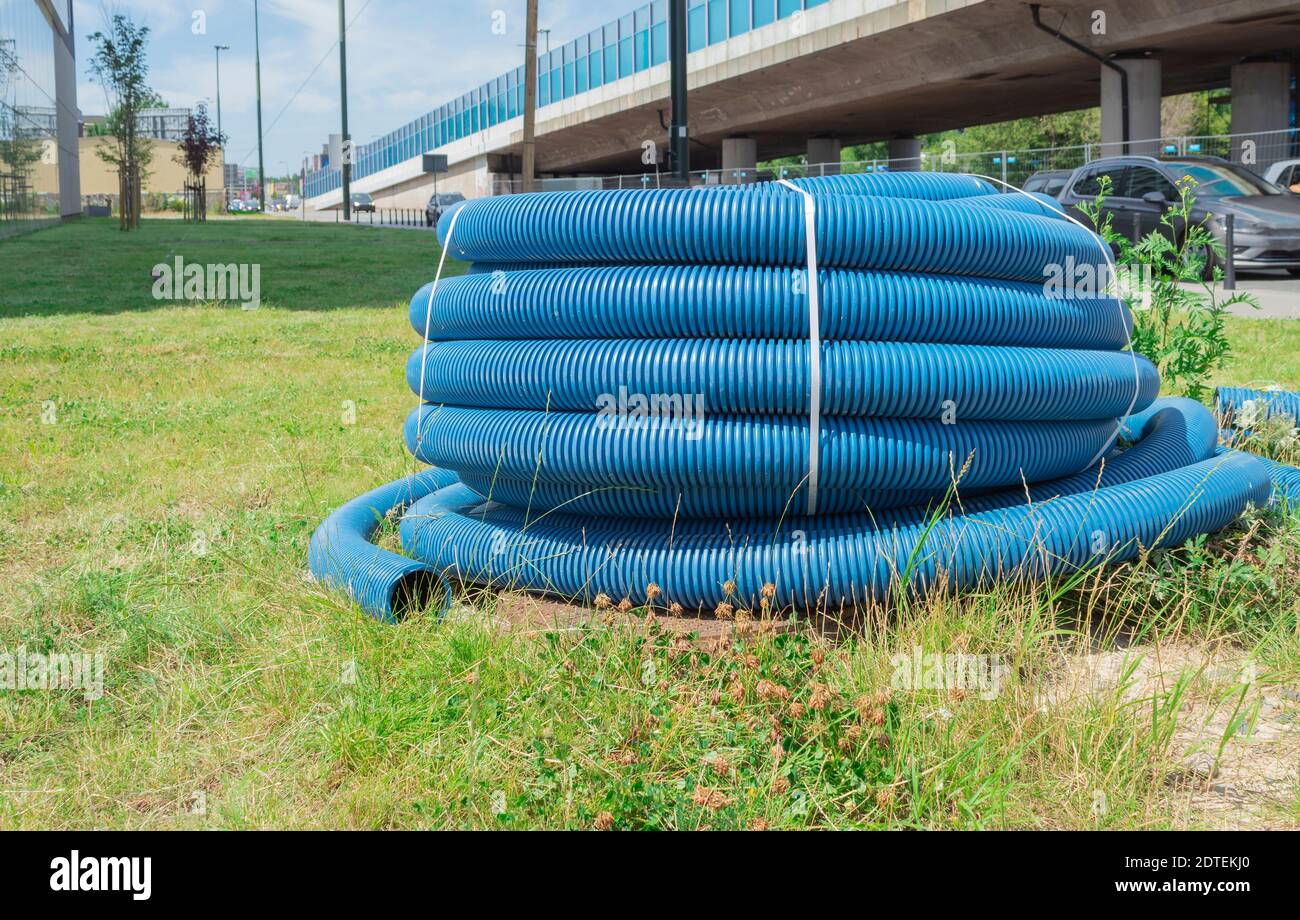 Corrugated pipe twisted into a roll. Blue corrugated pipe lies on the ...