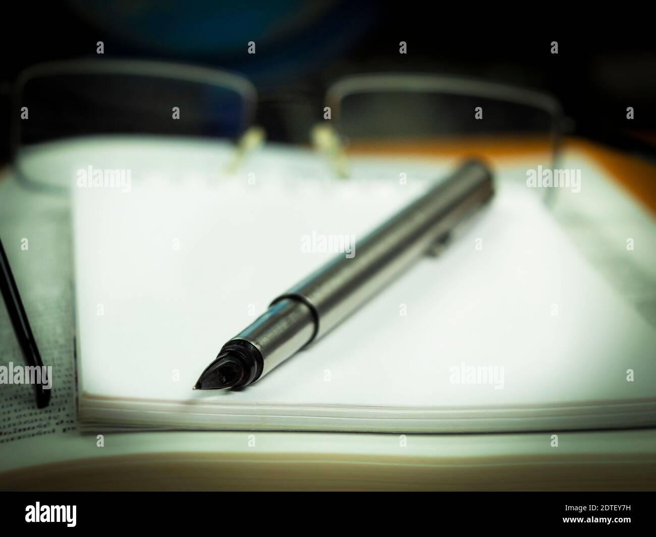 Ink pen and sheet of paper. Book with glasses Stock Photo - Alamy