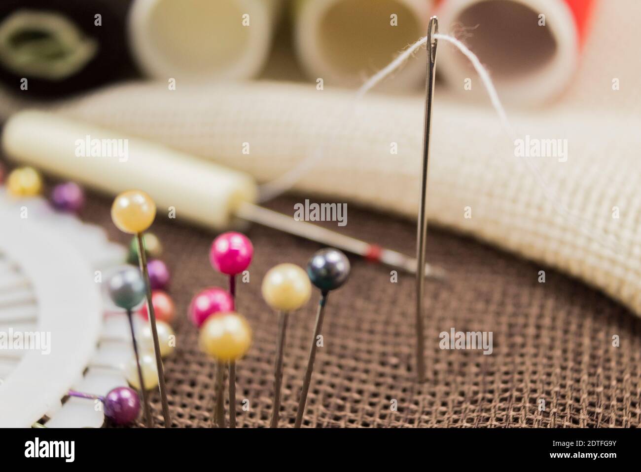 Threads and needle as wallpaper or background Stock Photo - Alamy