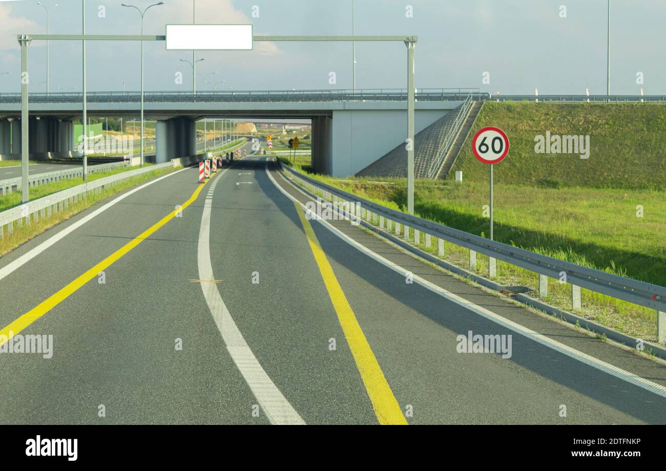 A road sign on a highway with a speed limit. View of the road from the ...