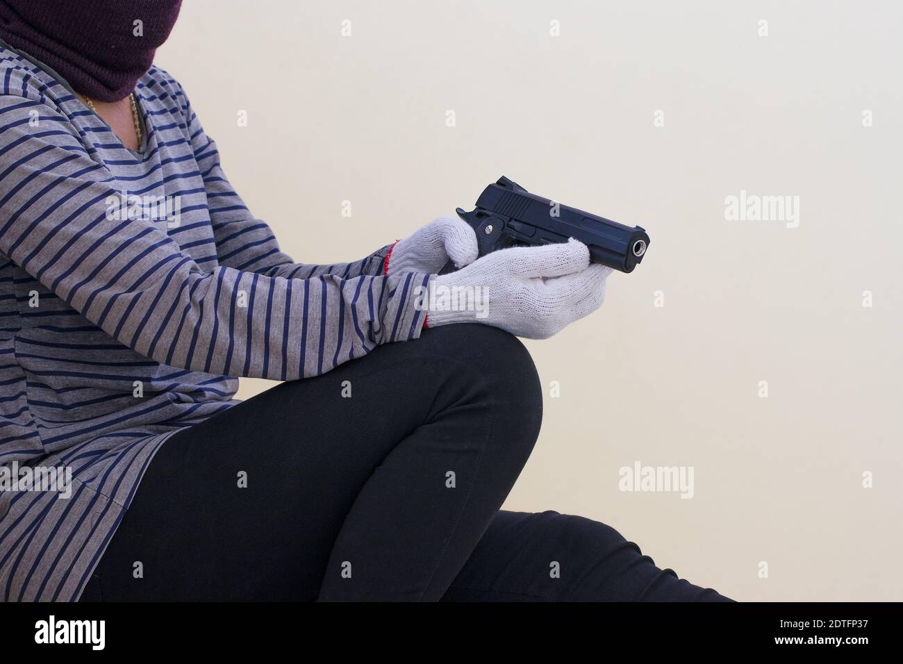 Rear View Of Man Holding Gun Against Wall Stock Photo - Alamy