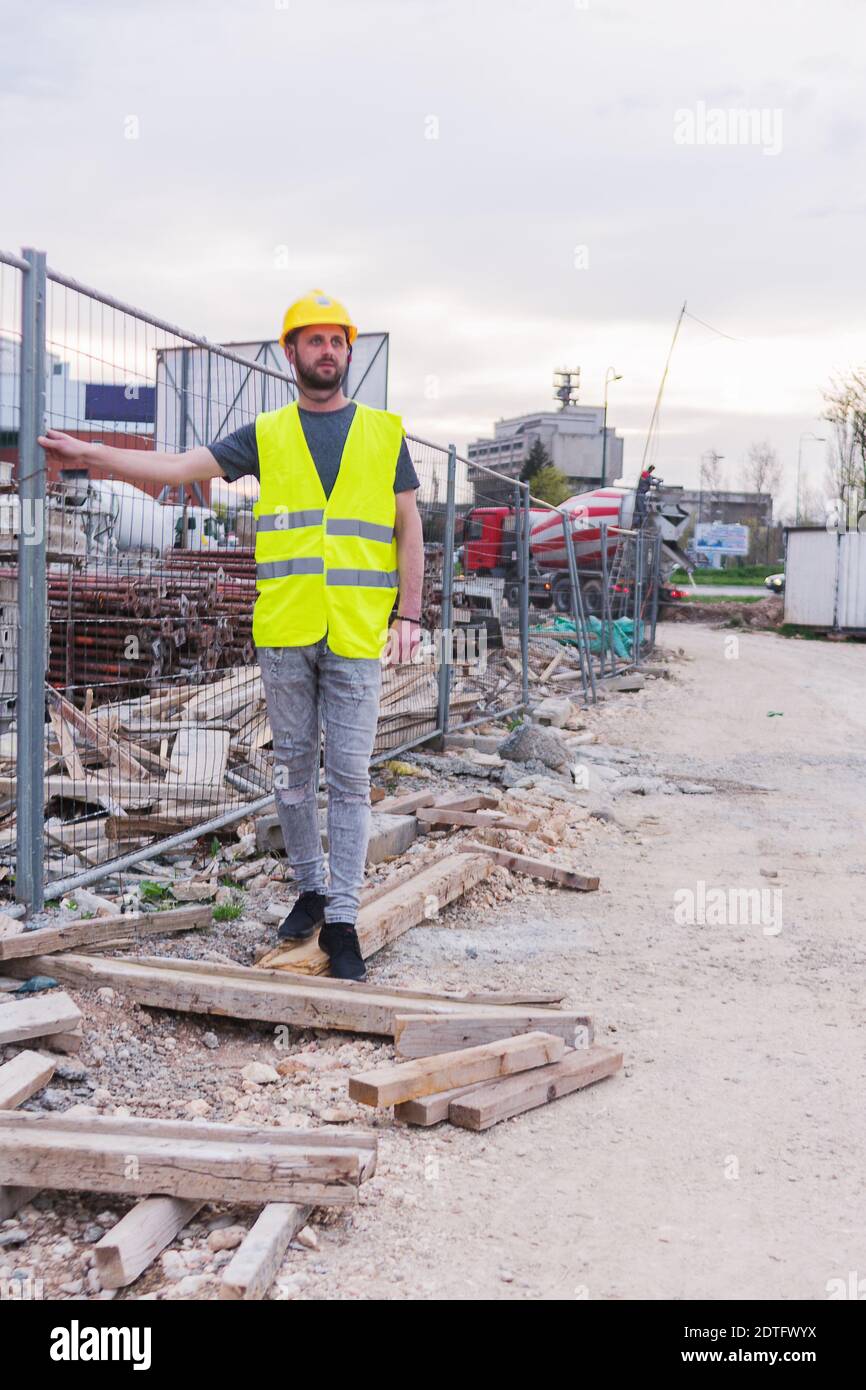 Full Length Of Man Standing By Fence At Construction Site Stock Photo ...