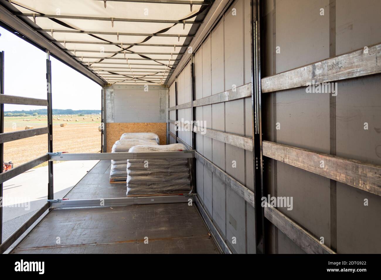 Loading goods onto a truck trailer. Unloading a trailer of pallets with ...